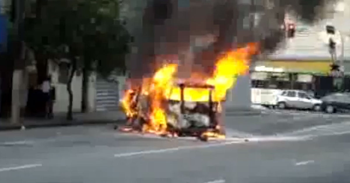 Man walks by exploding car - CBS News