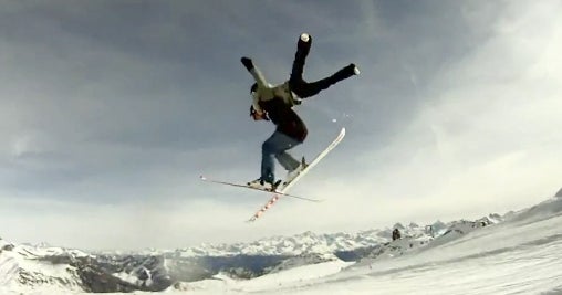 Watch a person ride piggy back on a skier doing a jump - CBS News