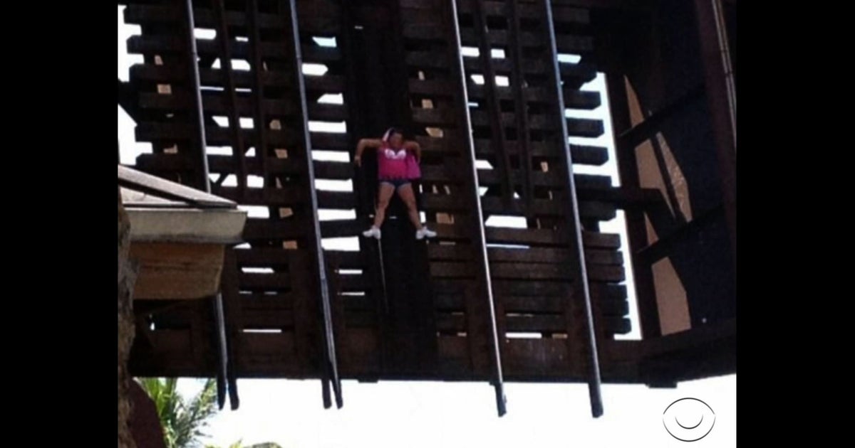 Woman rescued after dangling from railroad bridge - CBS News
