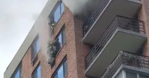 Firefighter rescues woman trapped in burning New York City high-rise ...