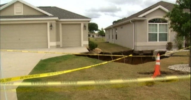Giant sinkhole opens up between two Orlando homes - CBS News