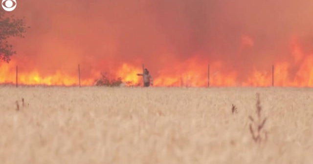 Man caught in wildfire escapes with clothes ablaze - CBS News