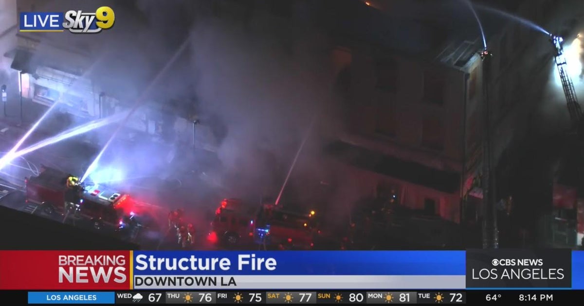 Several fire engines rain water down onto a blaze inside a downtown LA ...