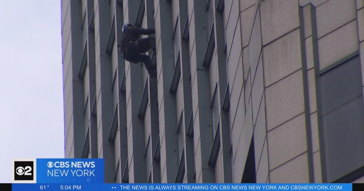 Man taken into custody after hanging out window for hours in Midtown ...