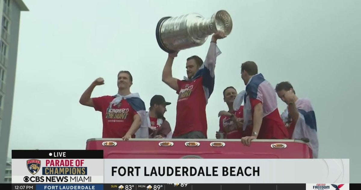 Fan walking along Florida Panthers parade buses as it nears end - CBS Miami