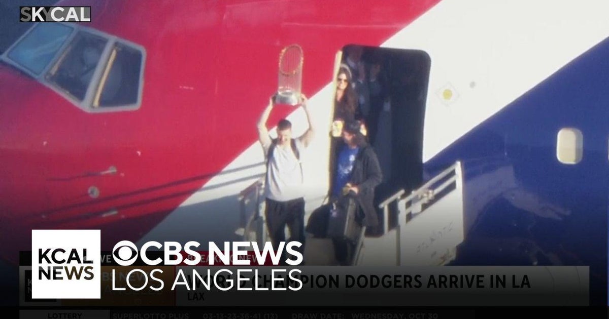 Walker Buehler holds up Commissioner's Trophy as Dodgers land at LAX ...